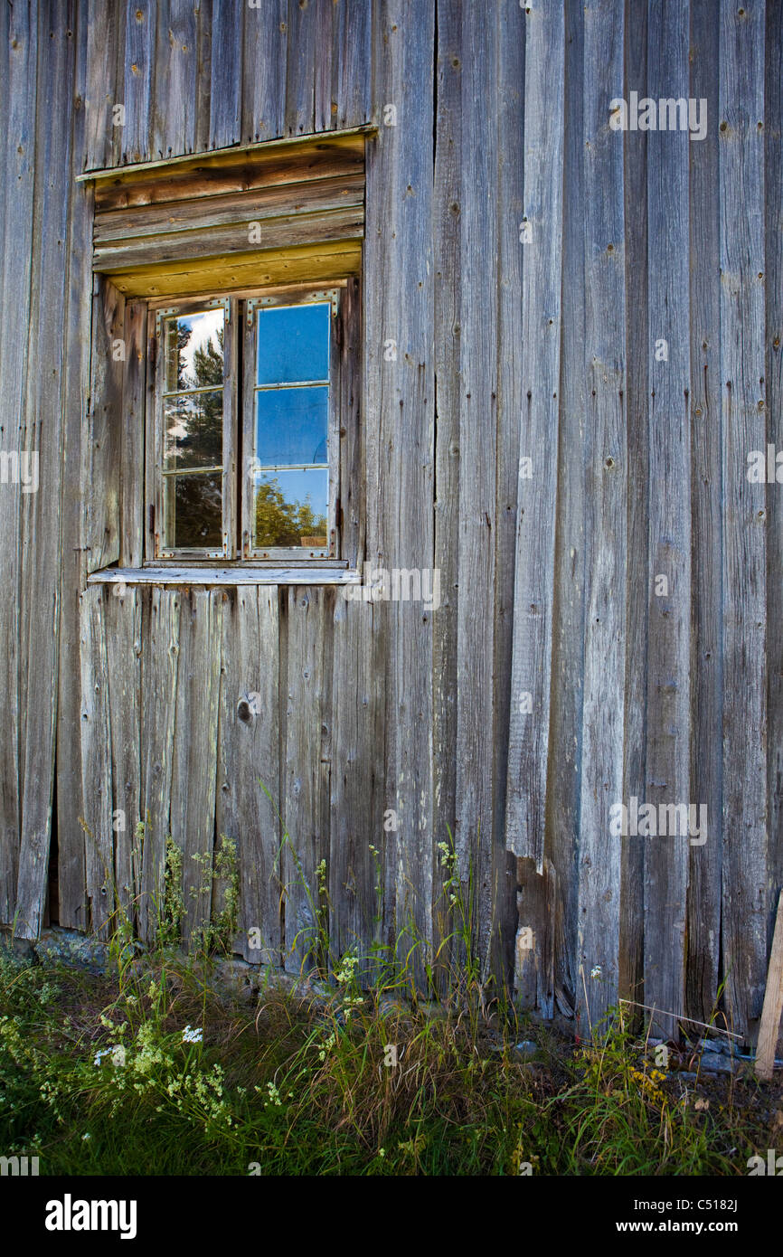 Old wooden cabin shed with window reflecting blue sky Stock Photo - Alamy