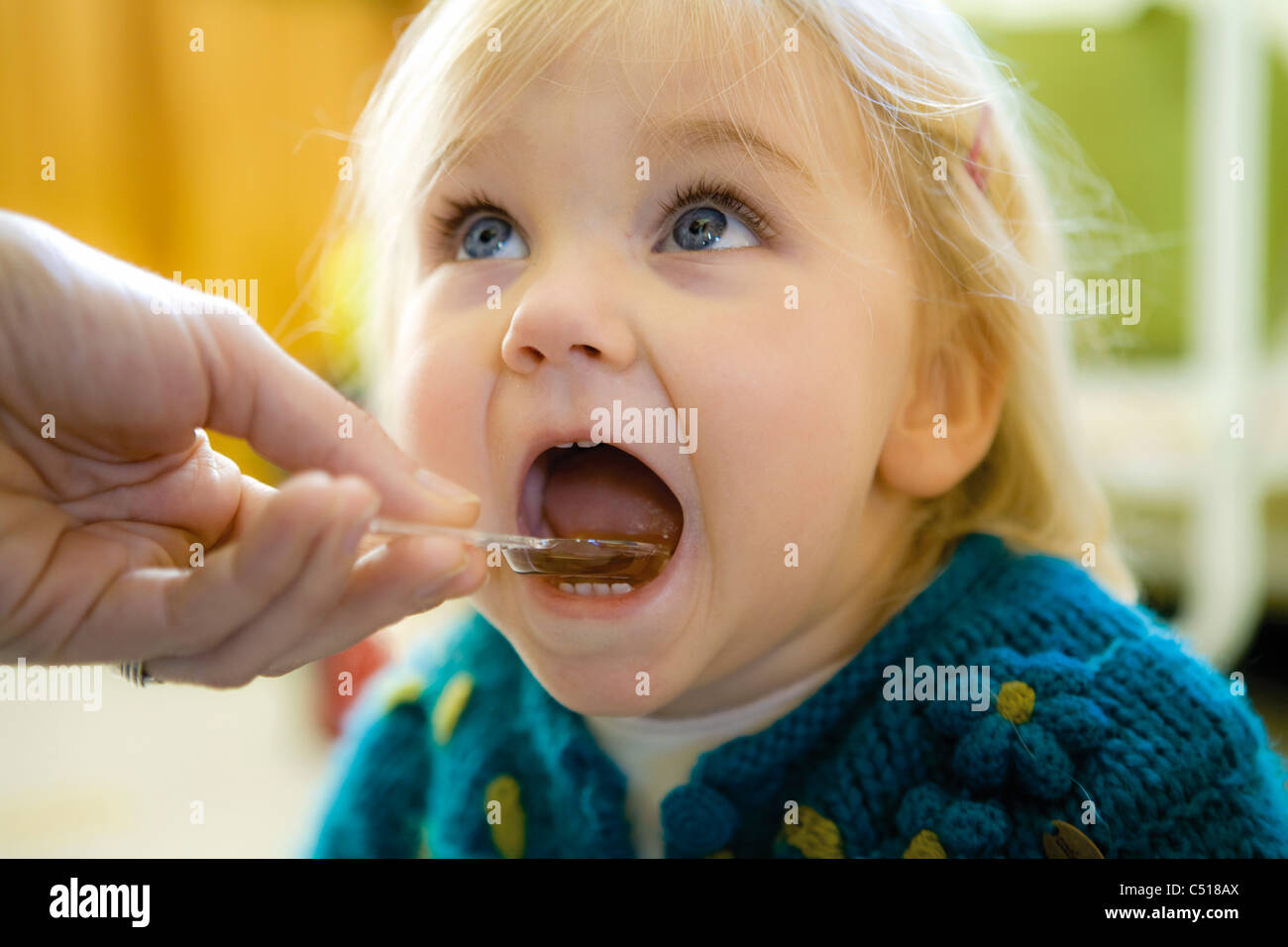 Baby girl being fed snack, cropped Stock Photo - Alamy