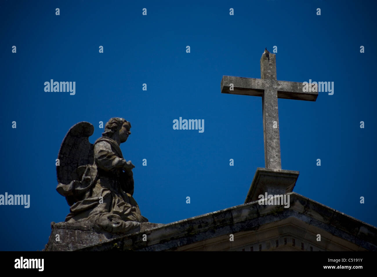 An angel stone sculpture and a cross decorate the facade of a church in ...