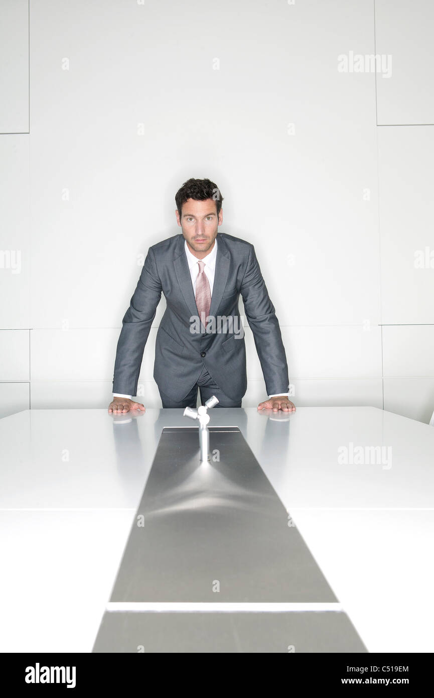portrait of businessman behind table in meeting room Stock Photo - Alamy