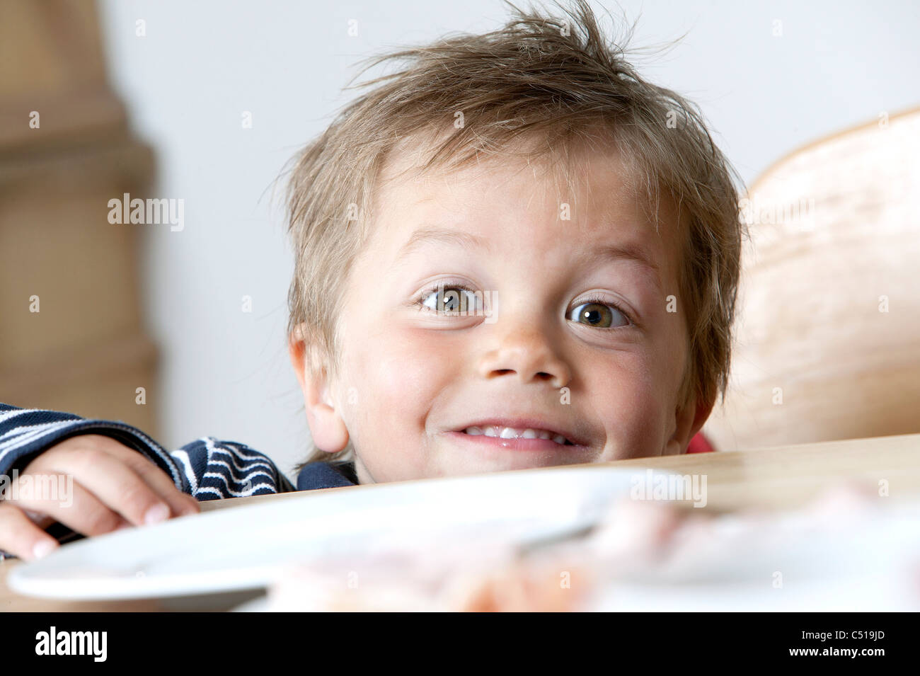 young boy peeking over table Stock Photo - Alamy