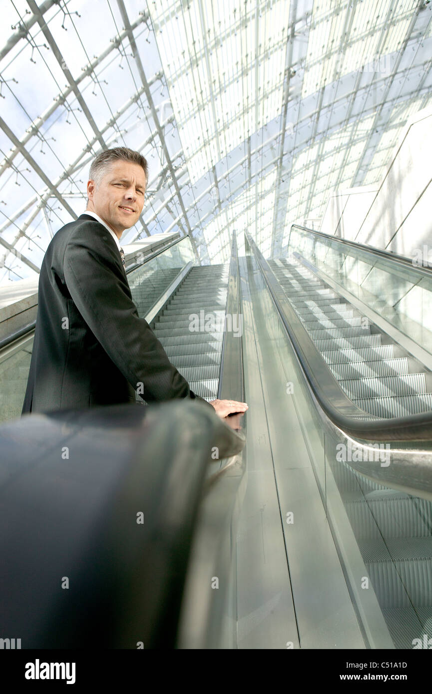 portrait of businessman on escalator Stock Photo - Alamy