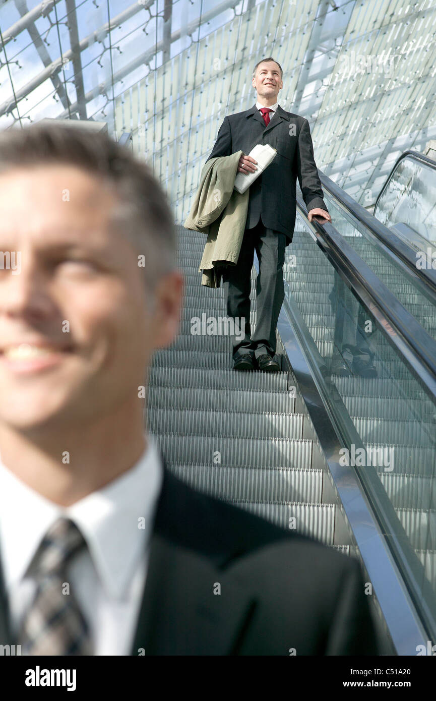 portrait of businessman on escalator Stock Photo - Alamy