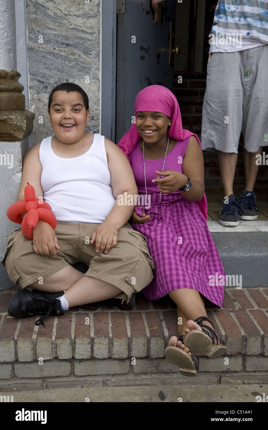 2011: Mermaid Parade, Coney Island, Brooklyn, NY. Friends sit on their ...
