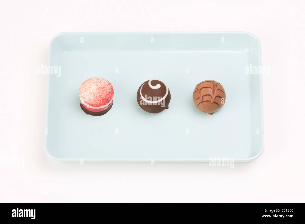 still life of three chocolate candies on a tray Stock Photo - Alamy