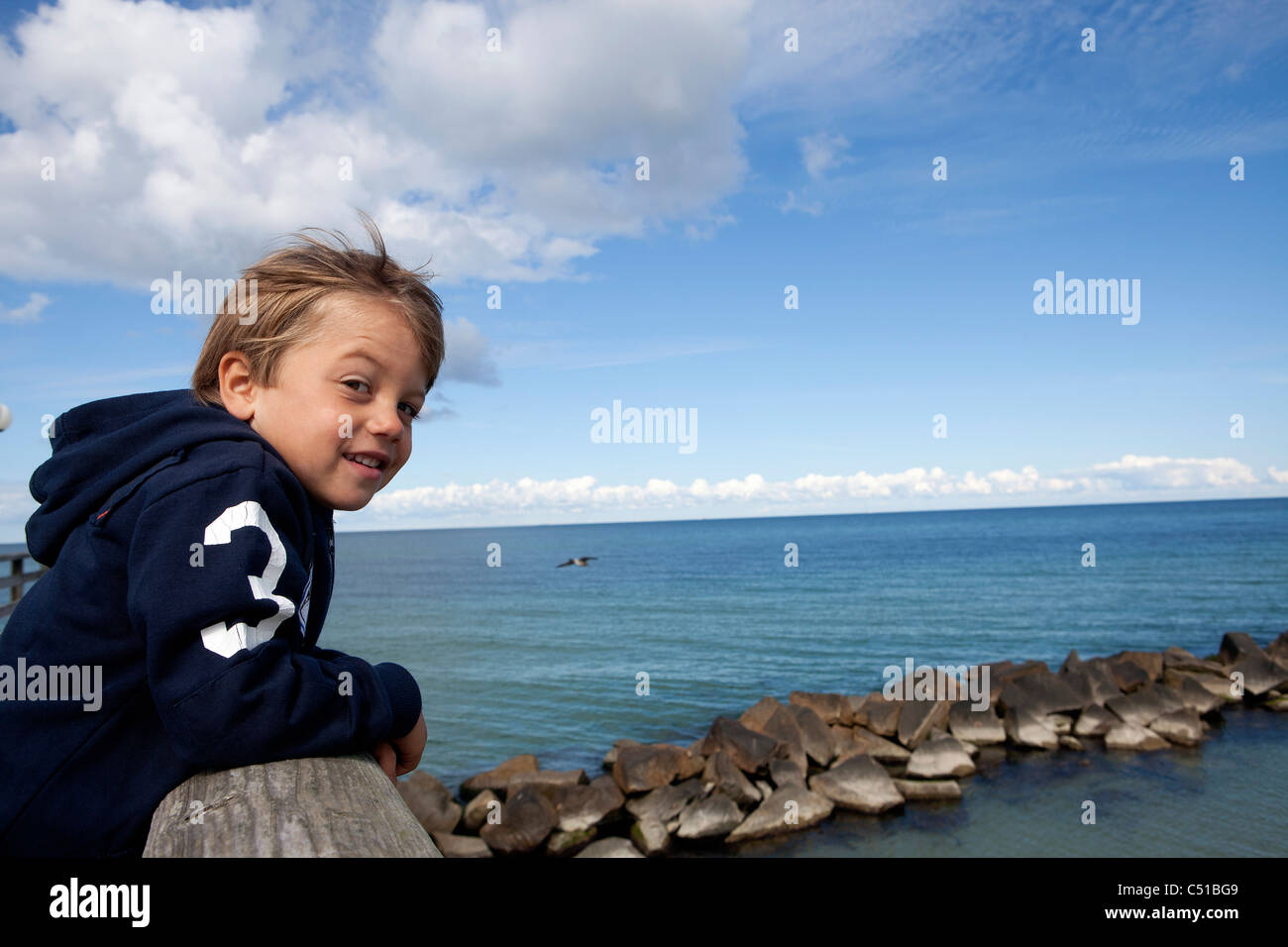 portrait of young boy standing on pier Stock Photo - Alamy