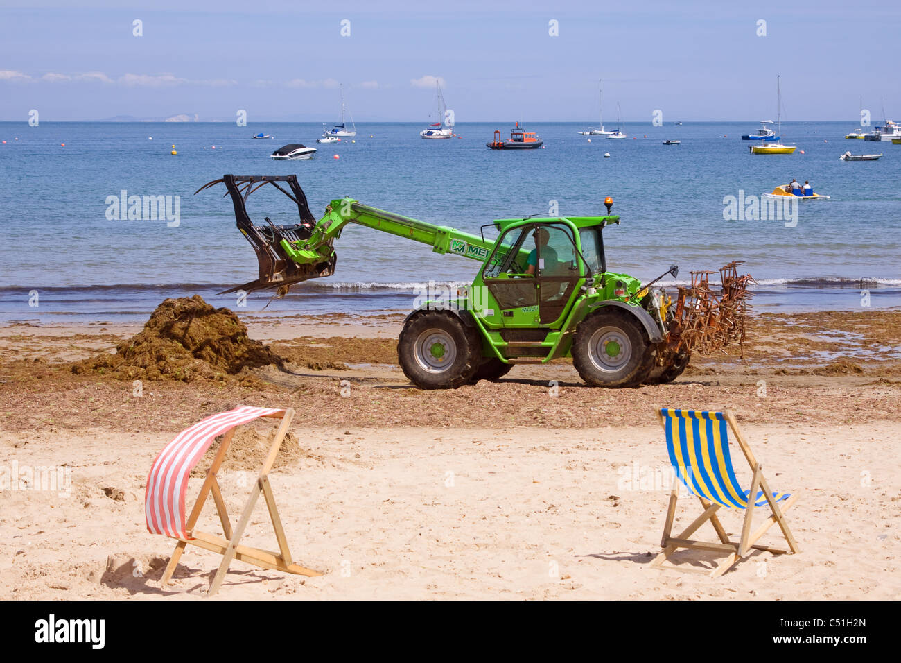 Tractor clearing away seaweed that had been washed up on the sand on ...