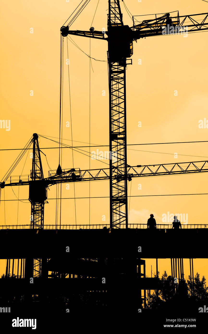 Two construction cranes and construction workers on site Stock Photo ...