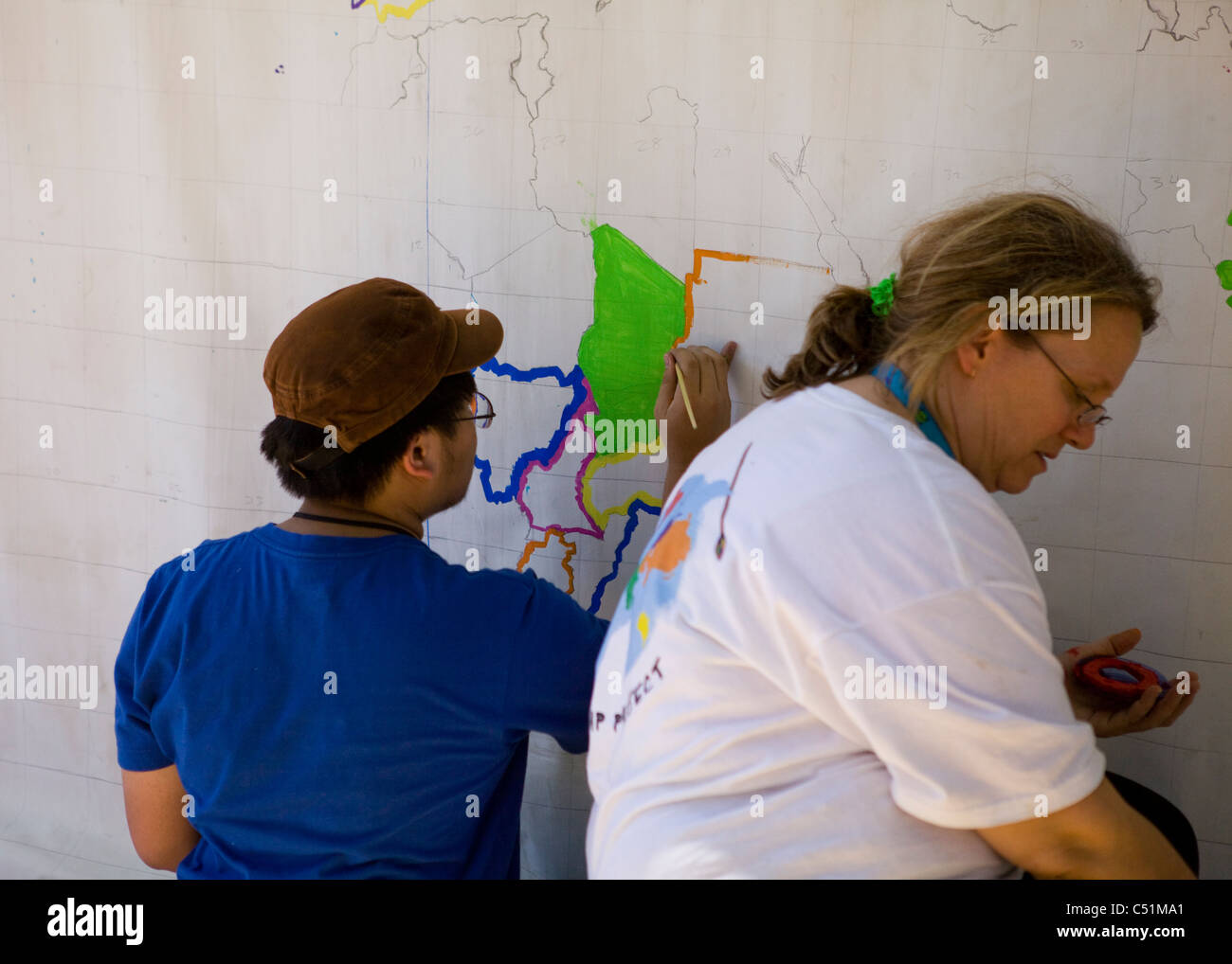 A man and woman painting the world map Stock Photo - Alamy