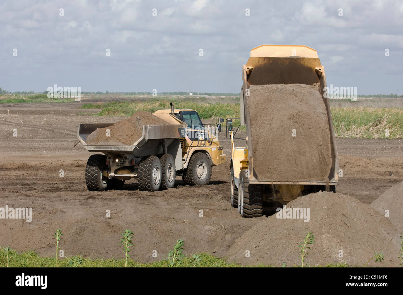 Earth moving construction equipment moving dirt Stock Photo - Alamy