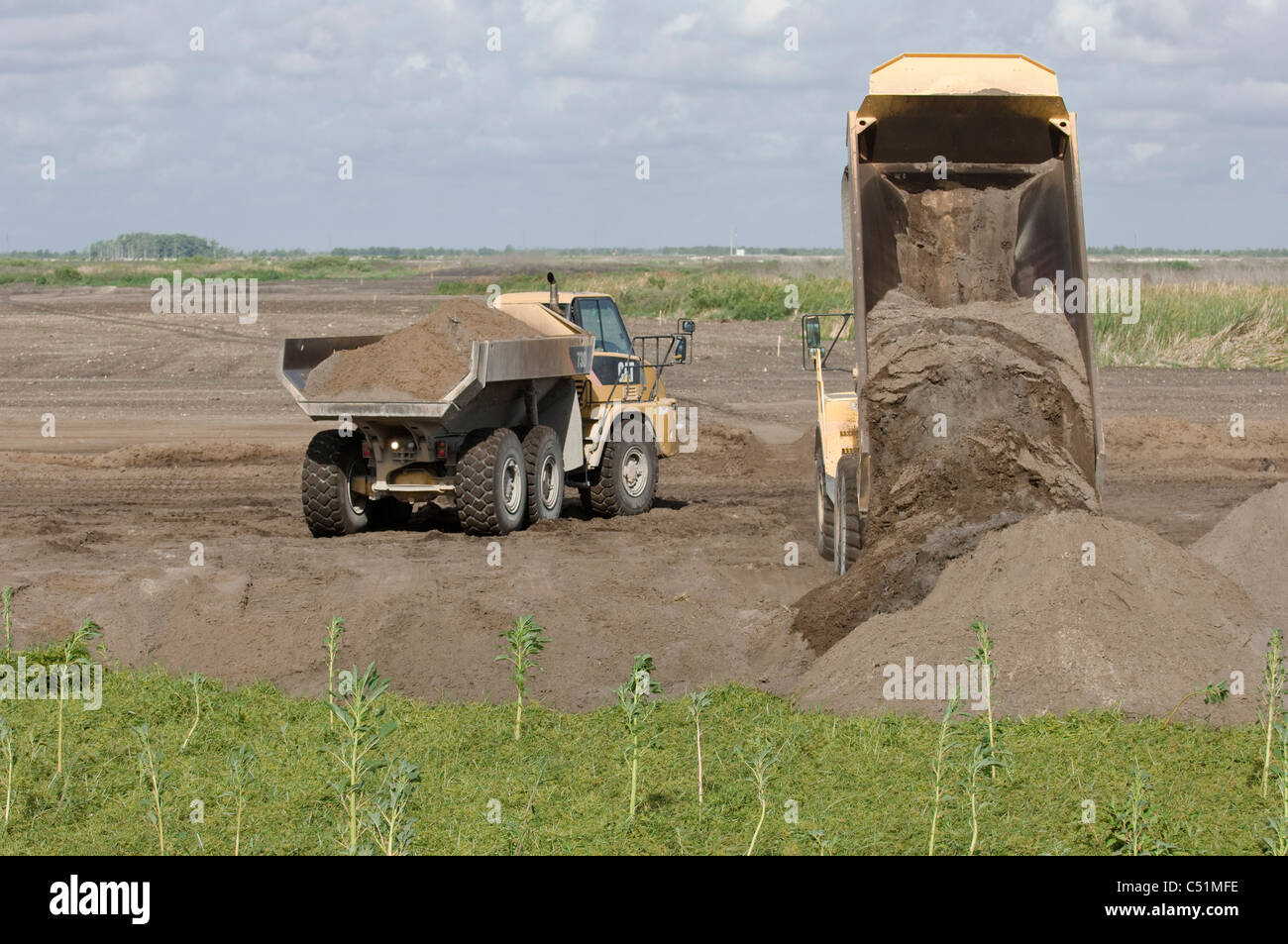 Earth moving construction equipment moving dirt Stock Photo - Alamy