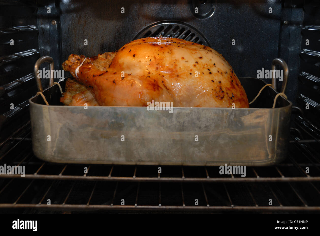 A turkey cooking in an open roasting pan inside an oven Stock Photo - Alamy