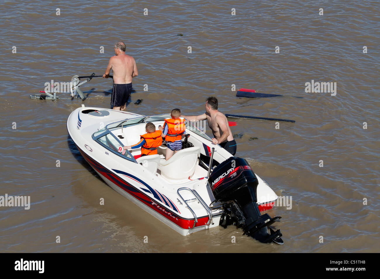 Removing a small speed boat from the water using a ramp Stock Photo - Alamy
