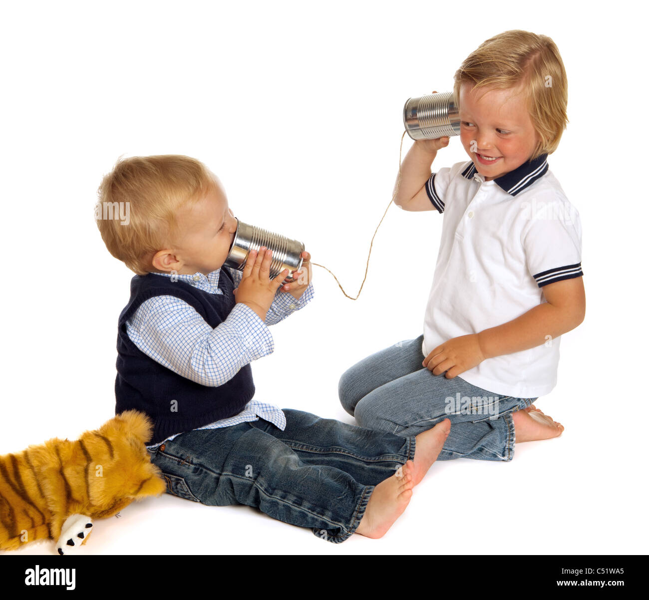 Two little brothers talking on the phone using two cans and a piece of ...