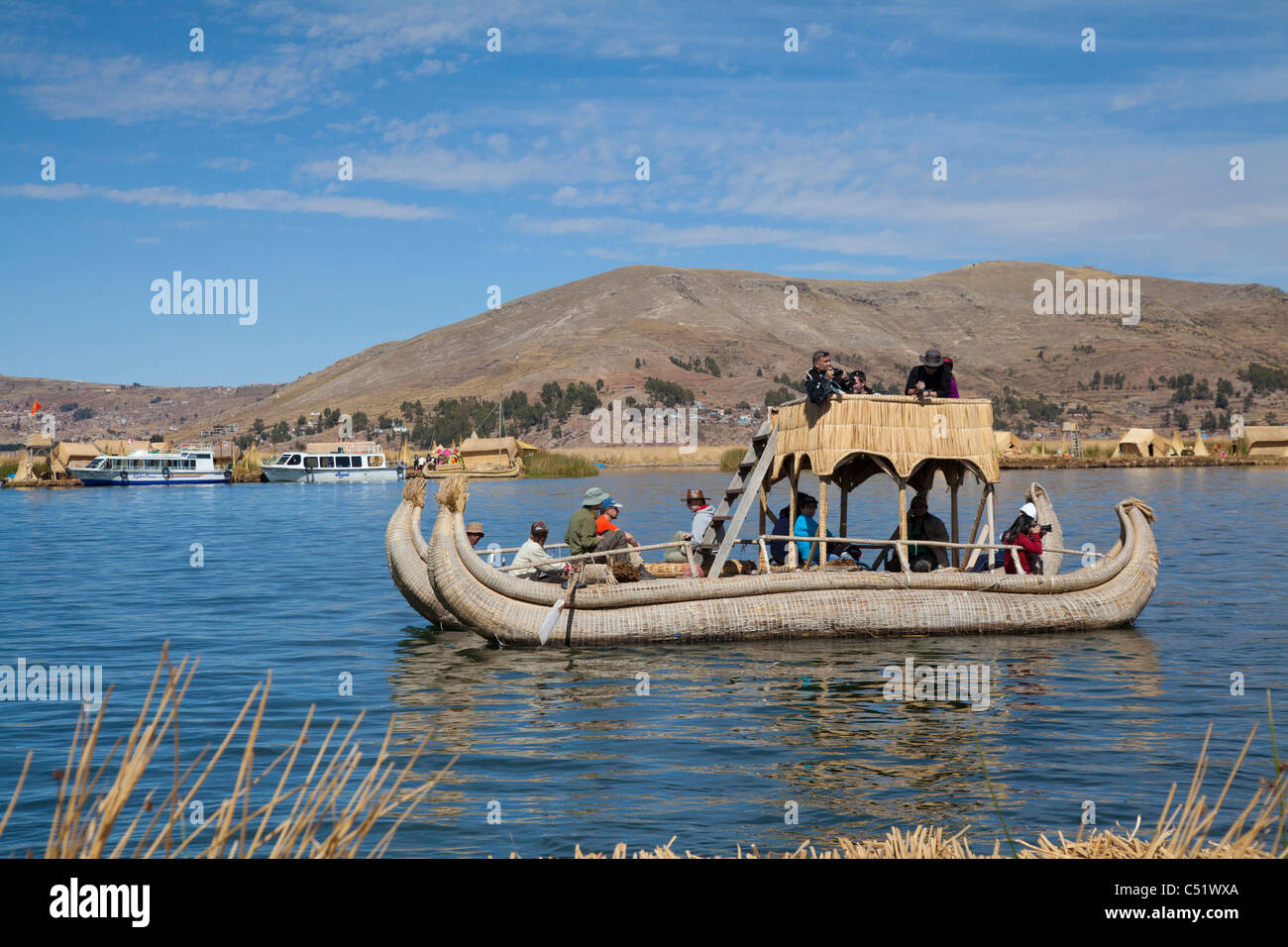 Tourists being rowed on a traditional boat, Uros Islands, Lake Titicaca ...