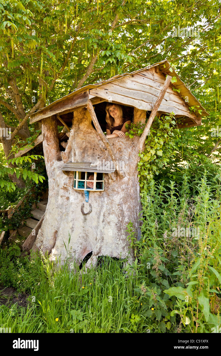 Two young women in beautiful traditional tree or Wendy house built by ...