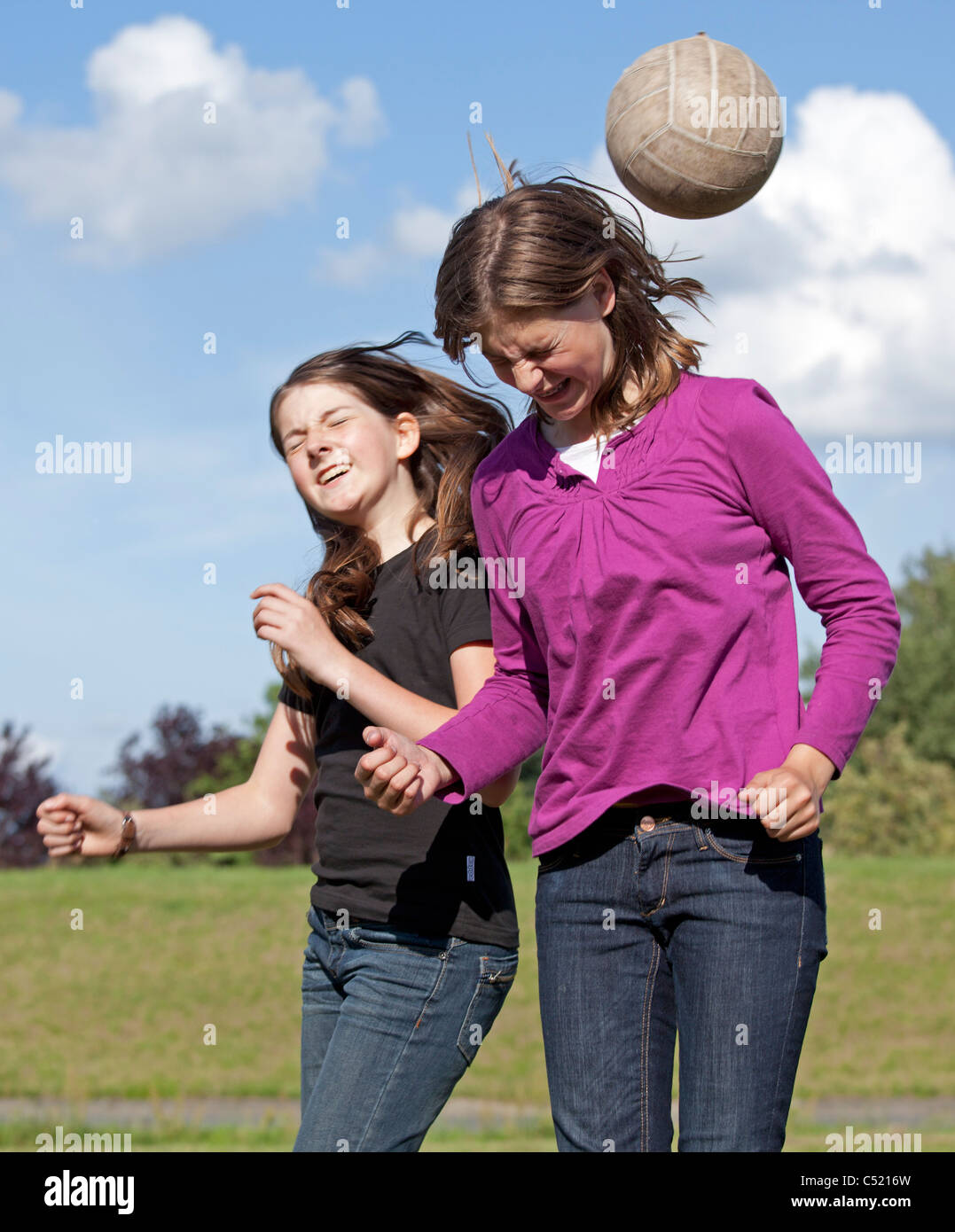 teenage girls trying to head a football Stock Photo - Alamy