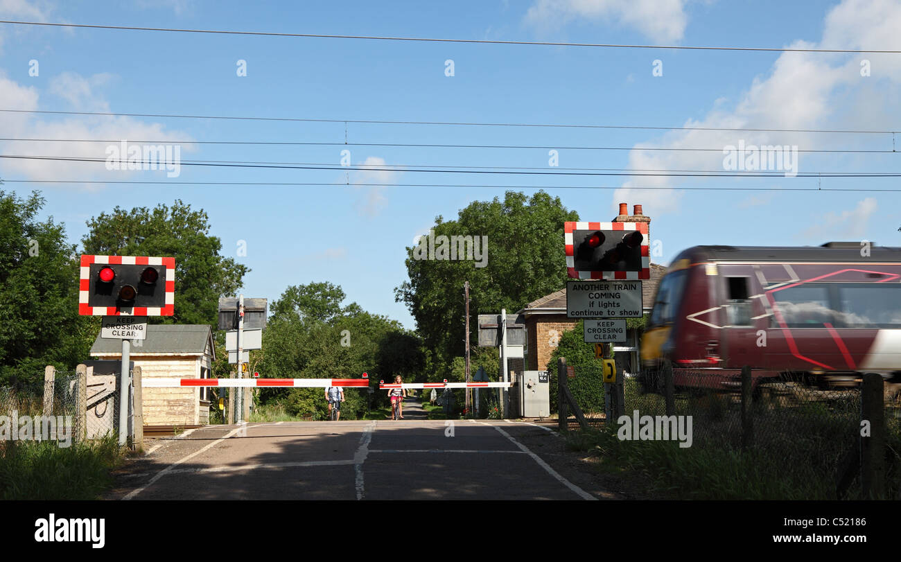 Cyclists waiting for train to pass at level crossing Milton ...
