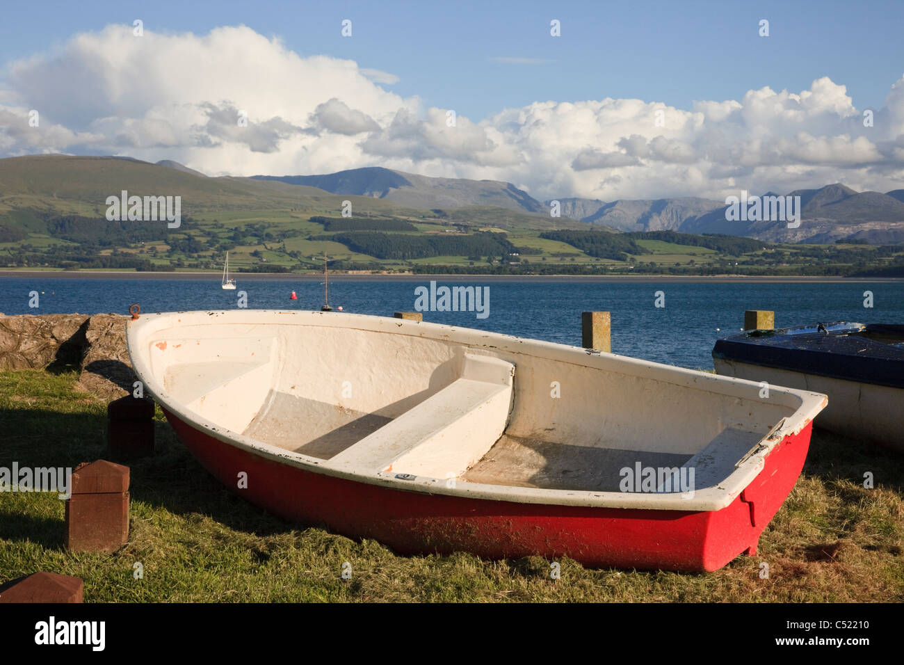 Boat on seafront with view to Welsh mountains across the Menai Strait ...