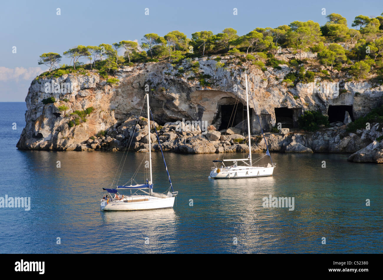 Sailing boats in front of the caves Coves de la Mare de Déu in the ...