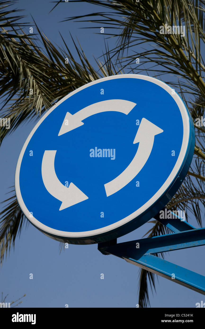 Round-a-bout Sign with Blue Sky and Palm Tree Background Stock Photo ...