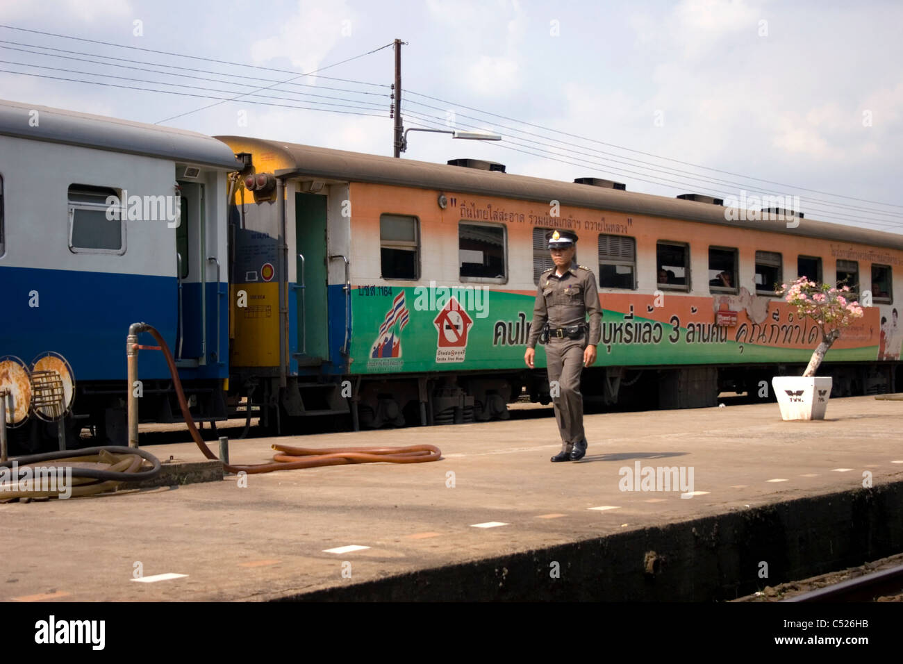 A policeman is patrolling a passenger train platform at a train station ...