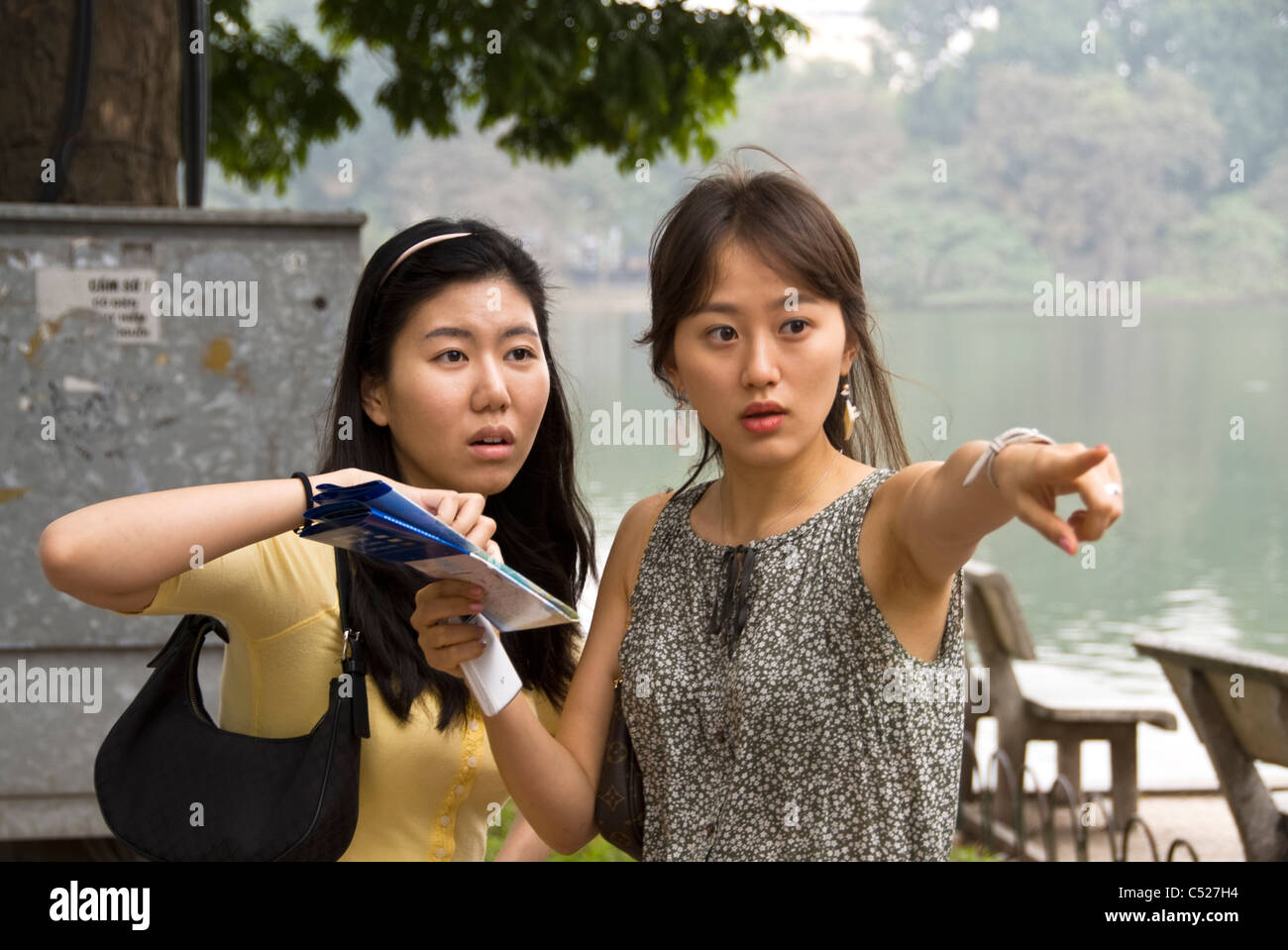 Two asian tourists, reading a map and pointing directions, Hanoi ...