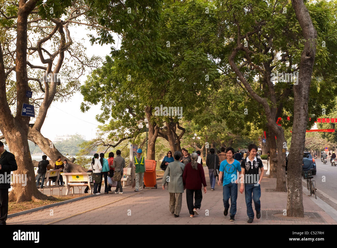 People walking on the lakeside footpath at Hoan Kiem Lake, Hanoi ...