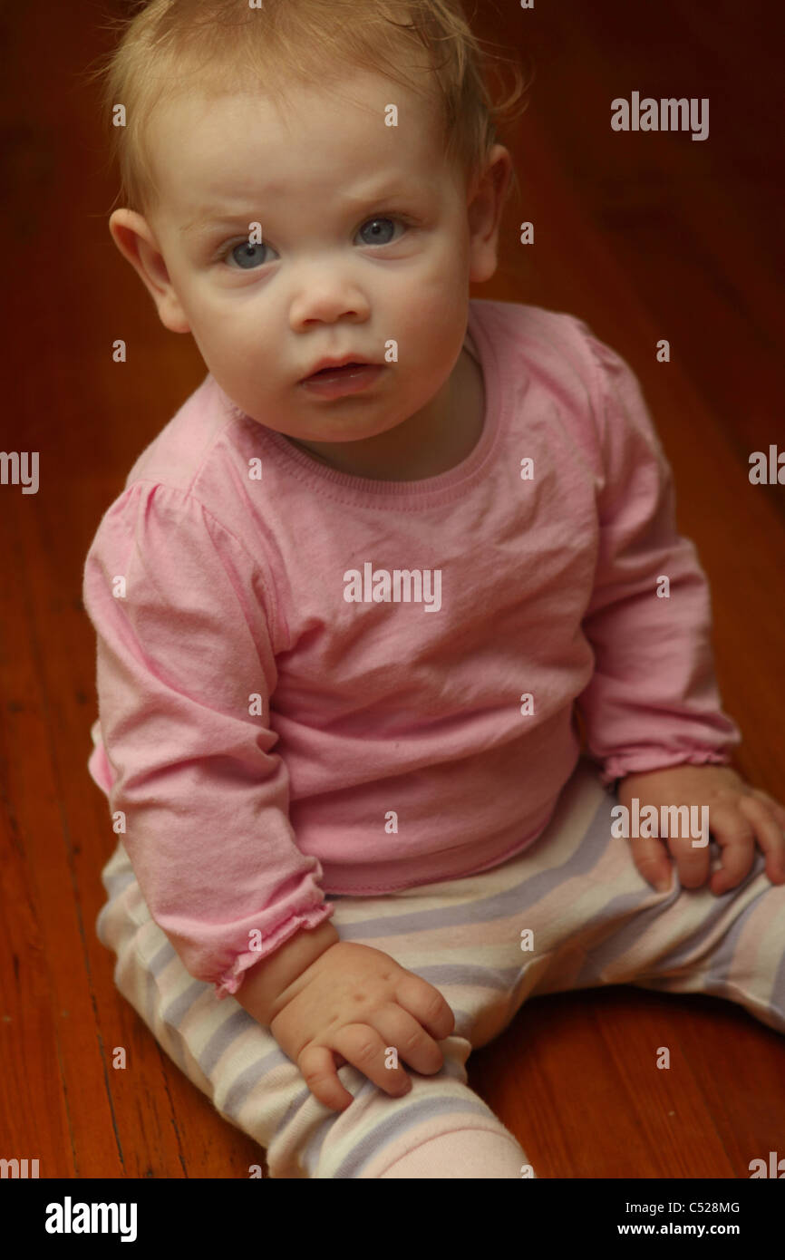 A small baby girl playing by herself Stock Photo - Alamy