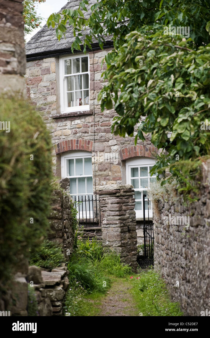 Traditional detached cottage on narrow footpath lane in village of ...