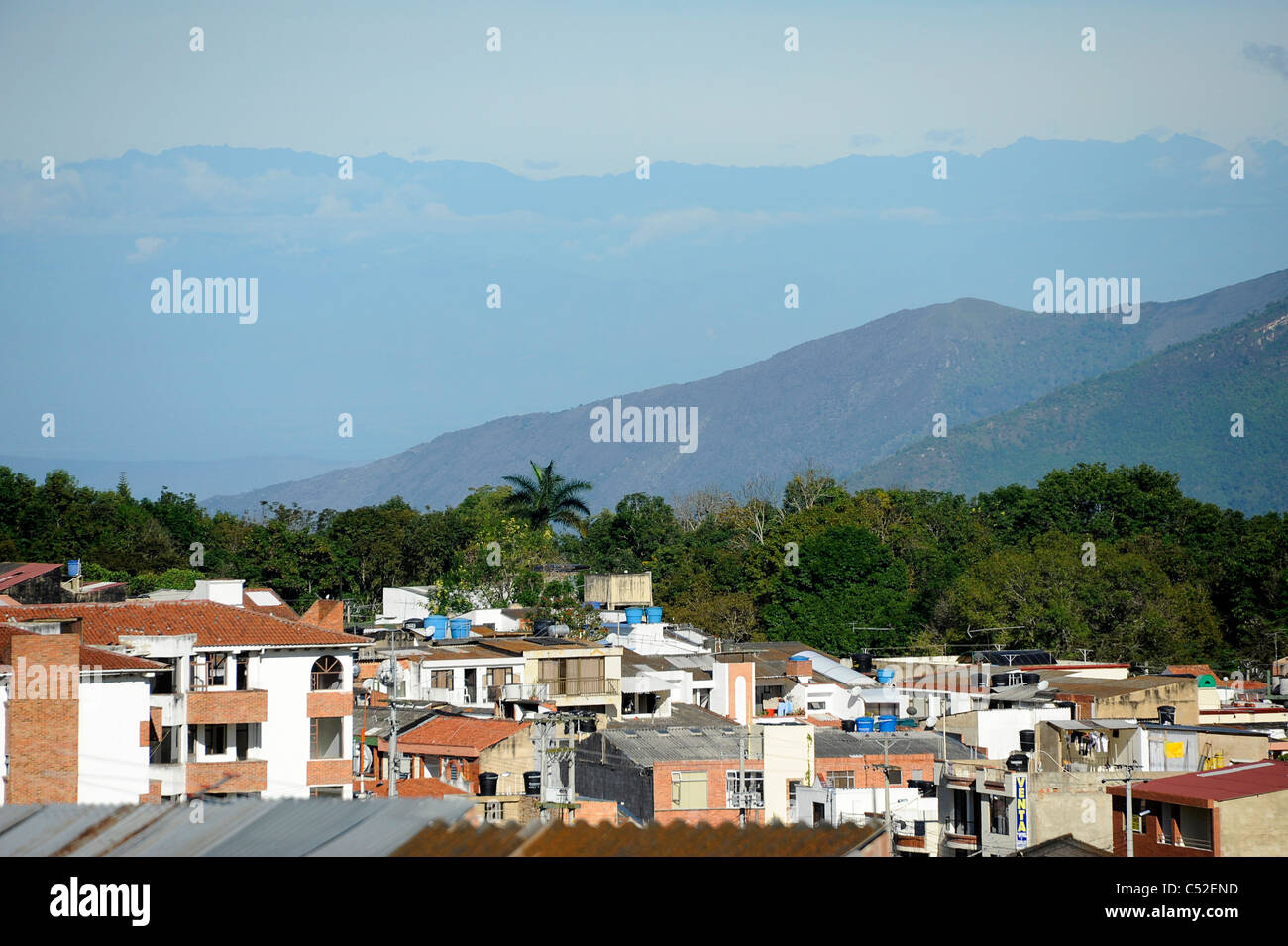 Rooftops and background of trees and mountains in the town of ...
