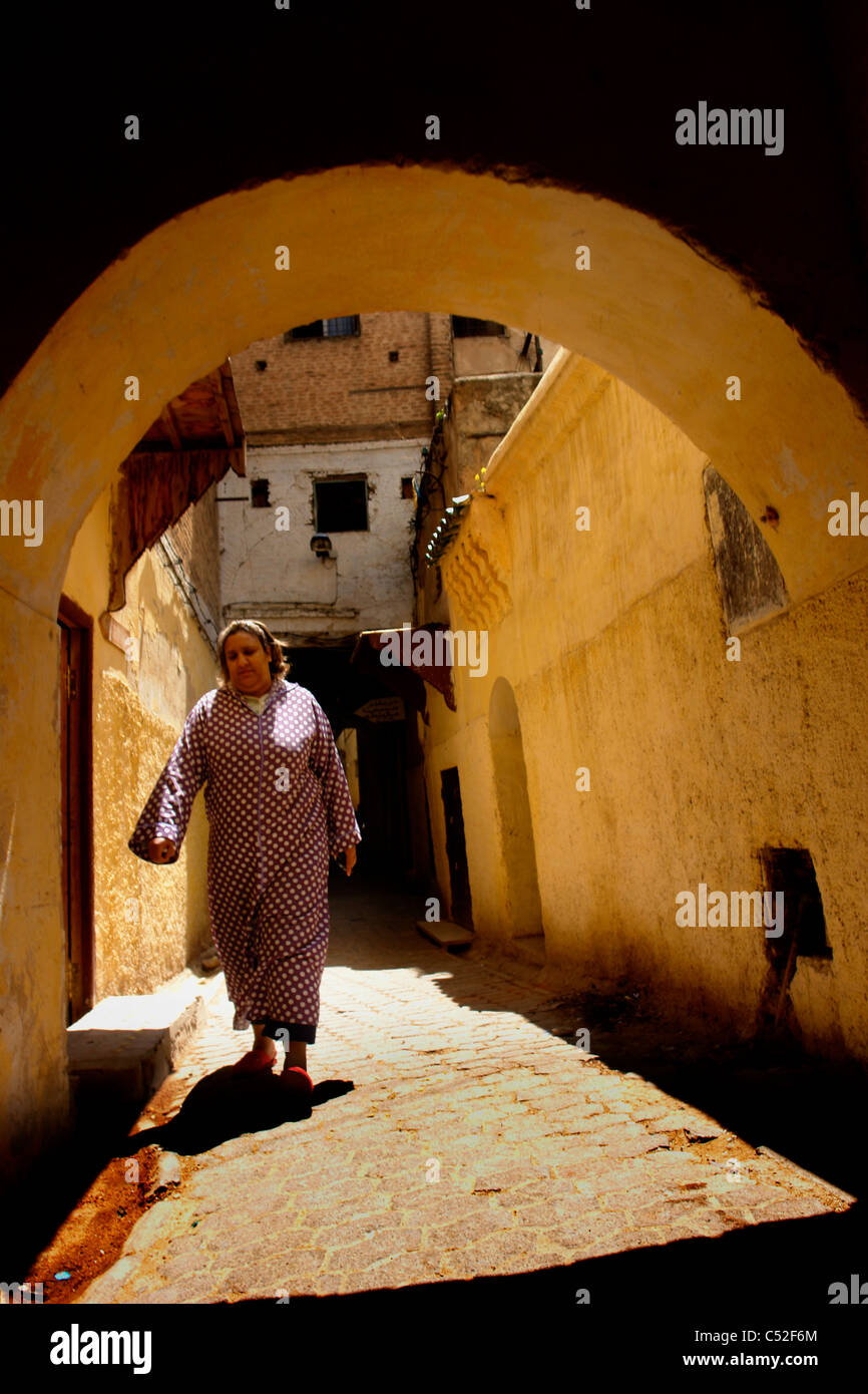 Woman walks through medina Stock Photo - Alamy