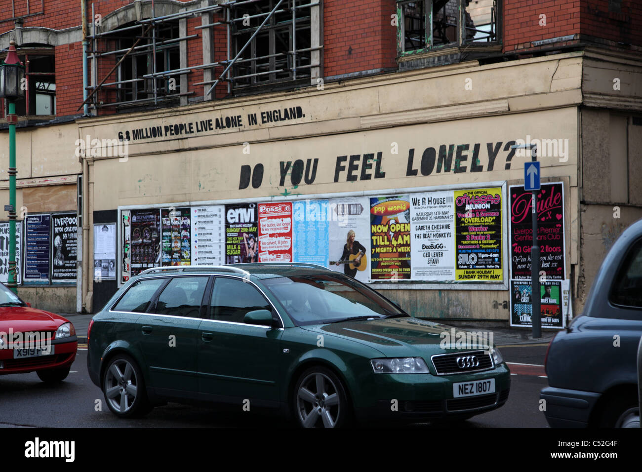 Derelict building in Liverpool with slogans and advertising posters ...