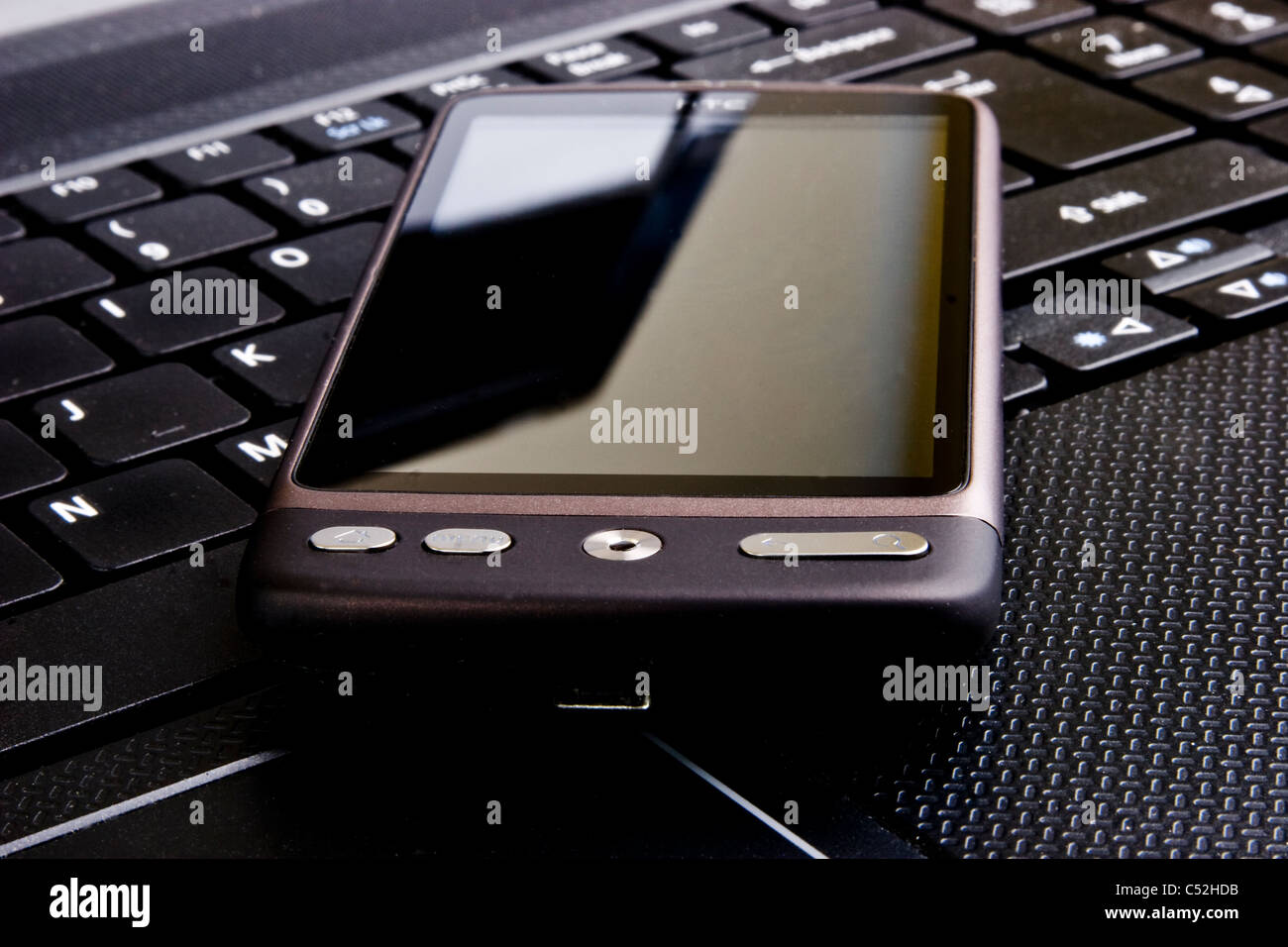 Smartphone on a laptop keyboard Stock Photo - Alamy