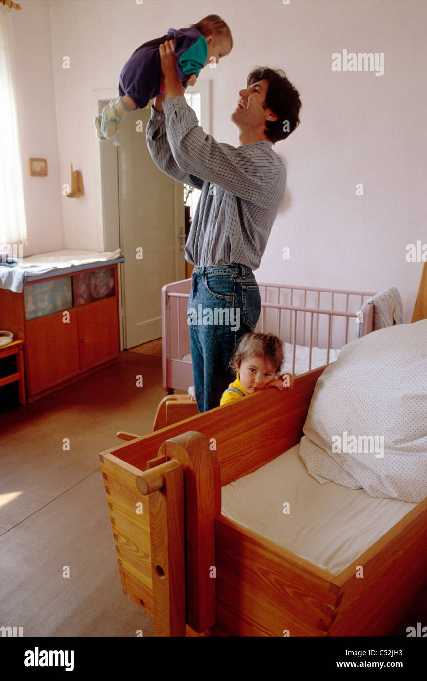 Father holds infant son in German nursery Stock Photo - Alamy