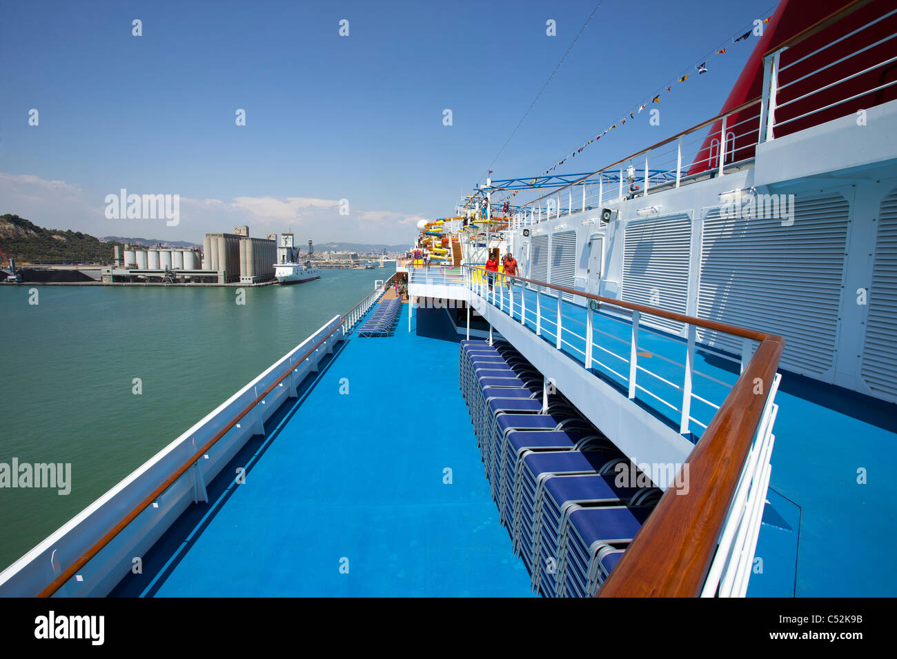Cruise ship deck with lounge chairs along rail over looking the ...