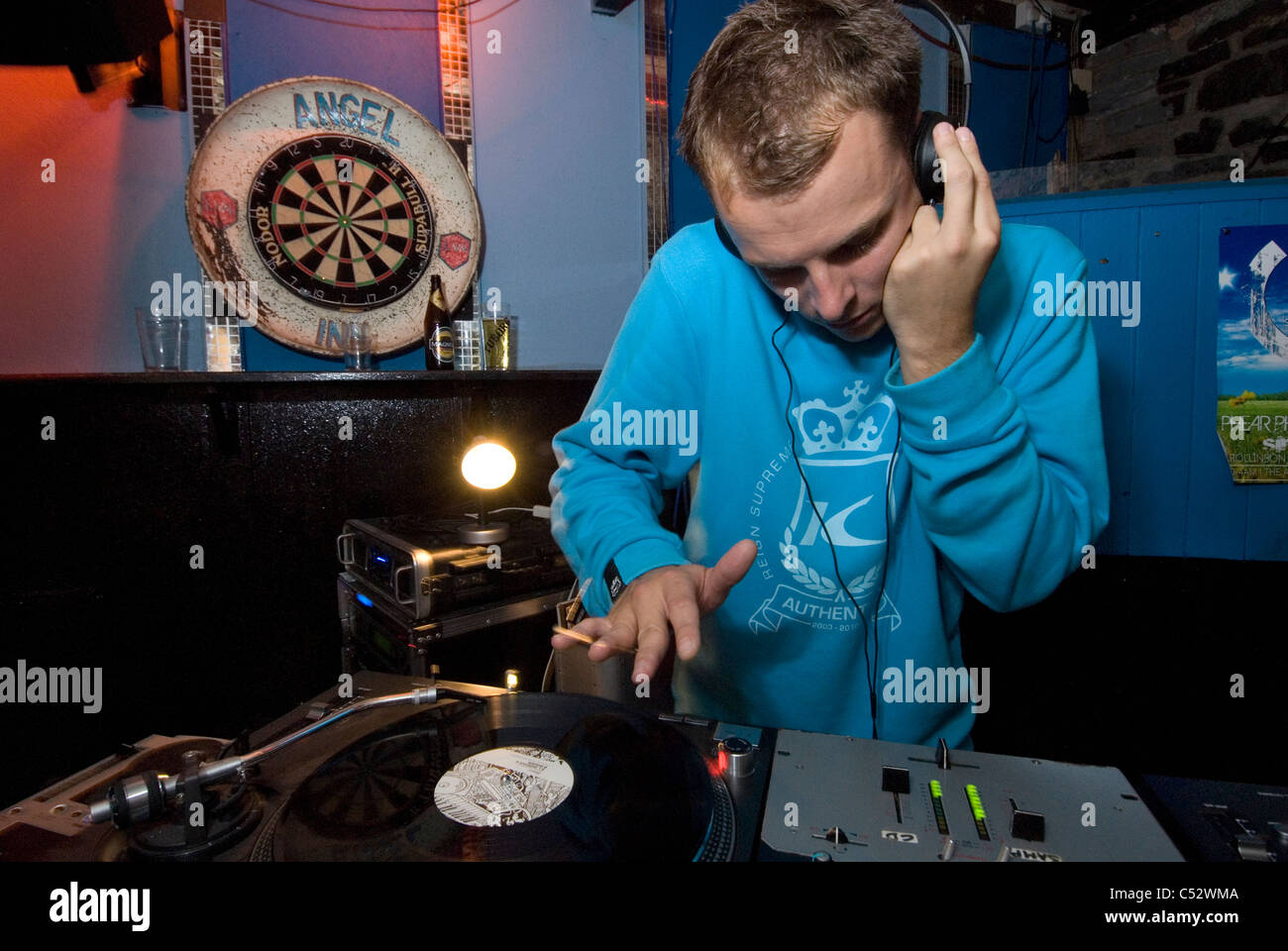 A young DJ scratching some vinyl on his decks Stock Photo - Alamy