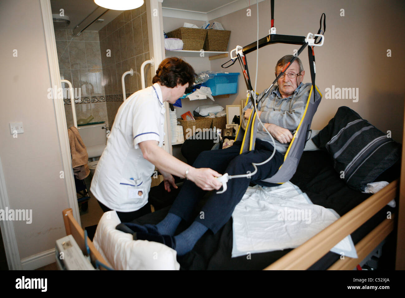 A 'Carewatch' worker caring for a customer in their own home Stock ...