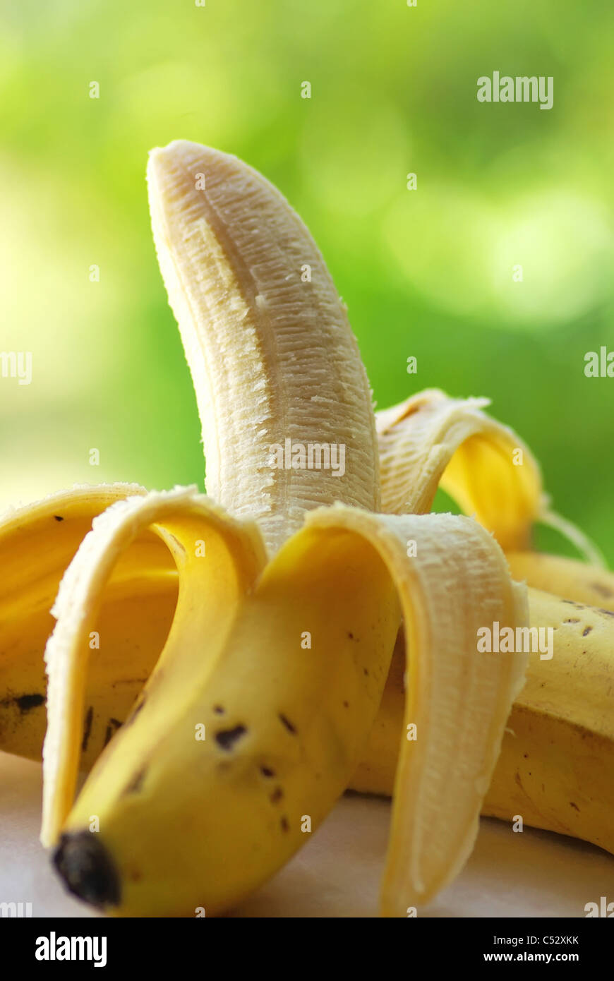 Open banana isolated on green background Stock Photo - Alamy