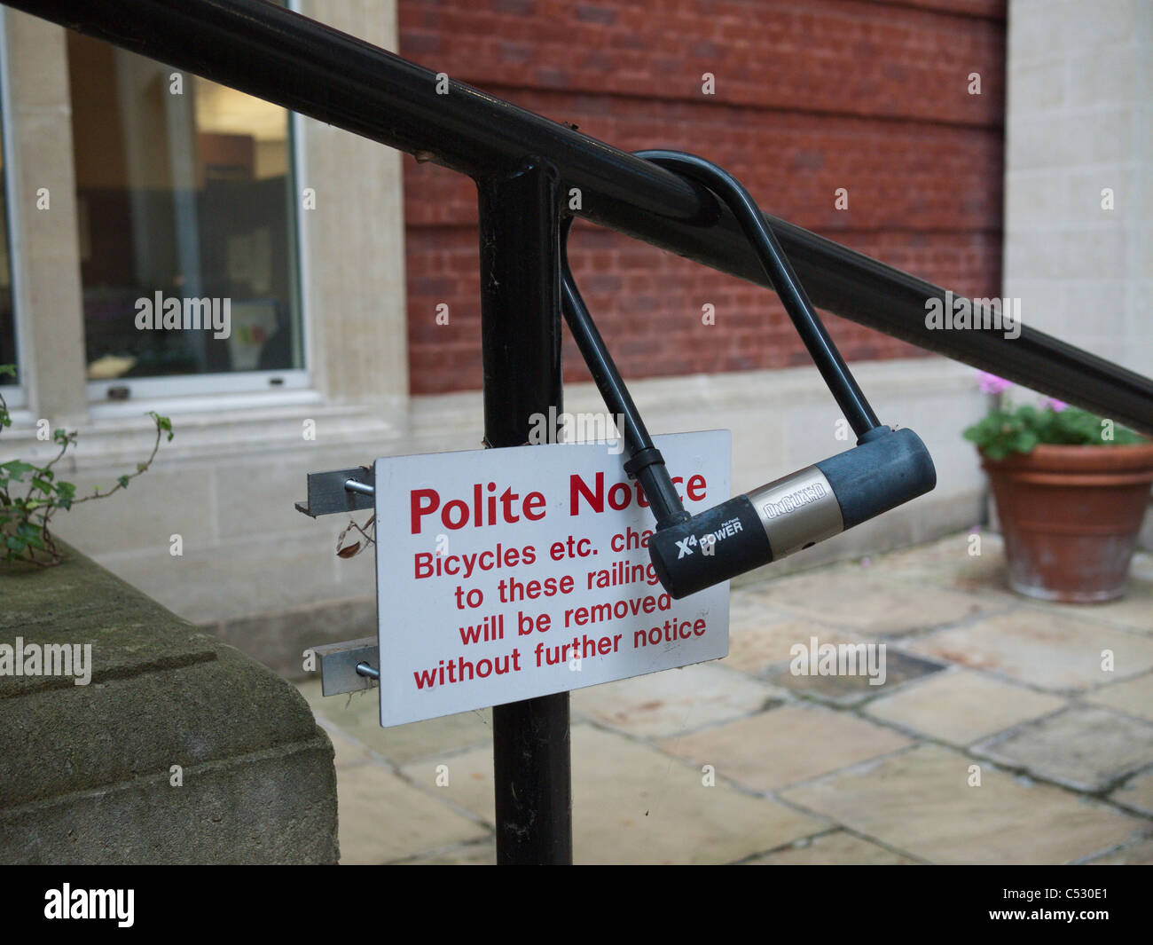 Notice saying bicycles will be removed with bicycle lock attached Stock ...