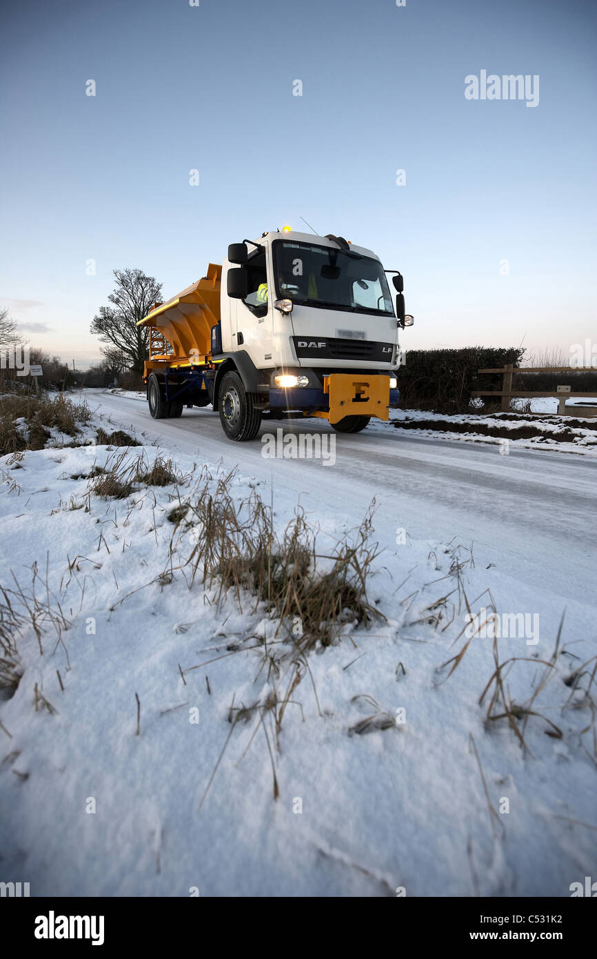 Gritter spreading grit over a snow covered lane, UK Stock Photo - Alamy