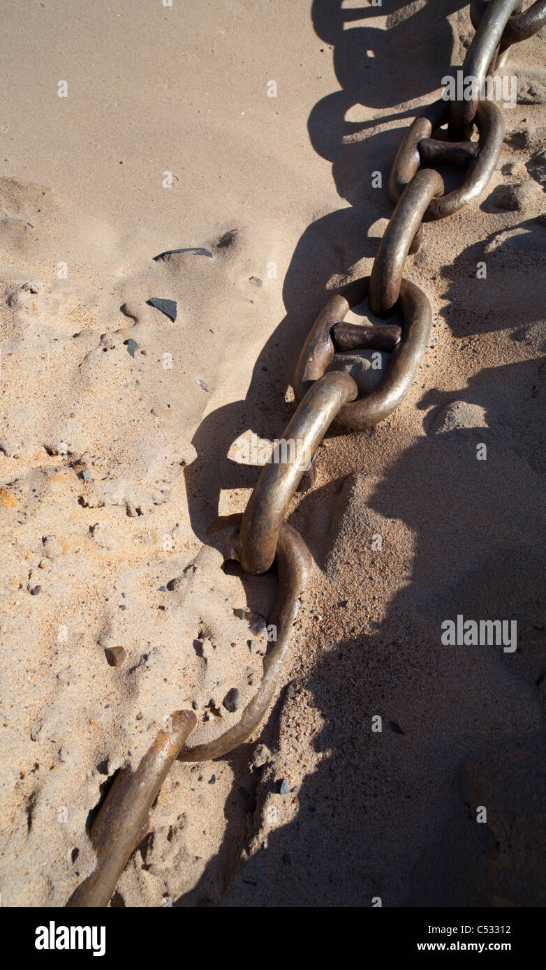 Heavy-duty iron chain half buried to sand Stock Photo - Alamy
