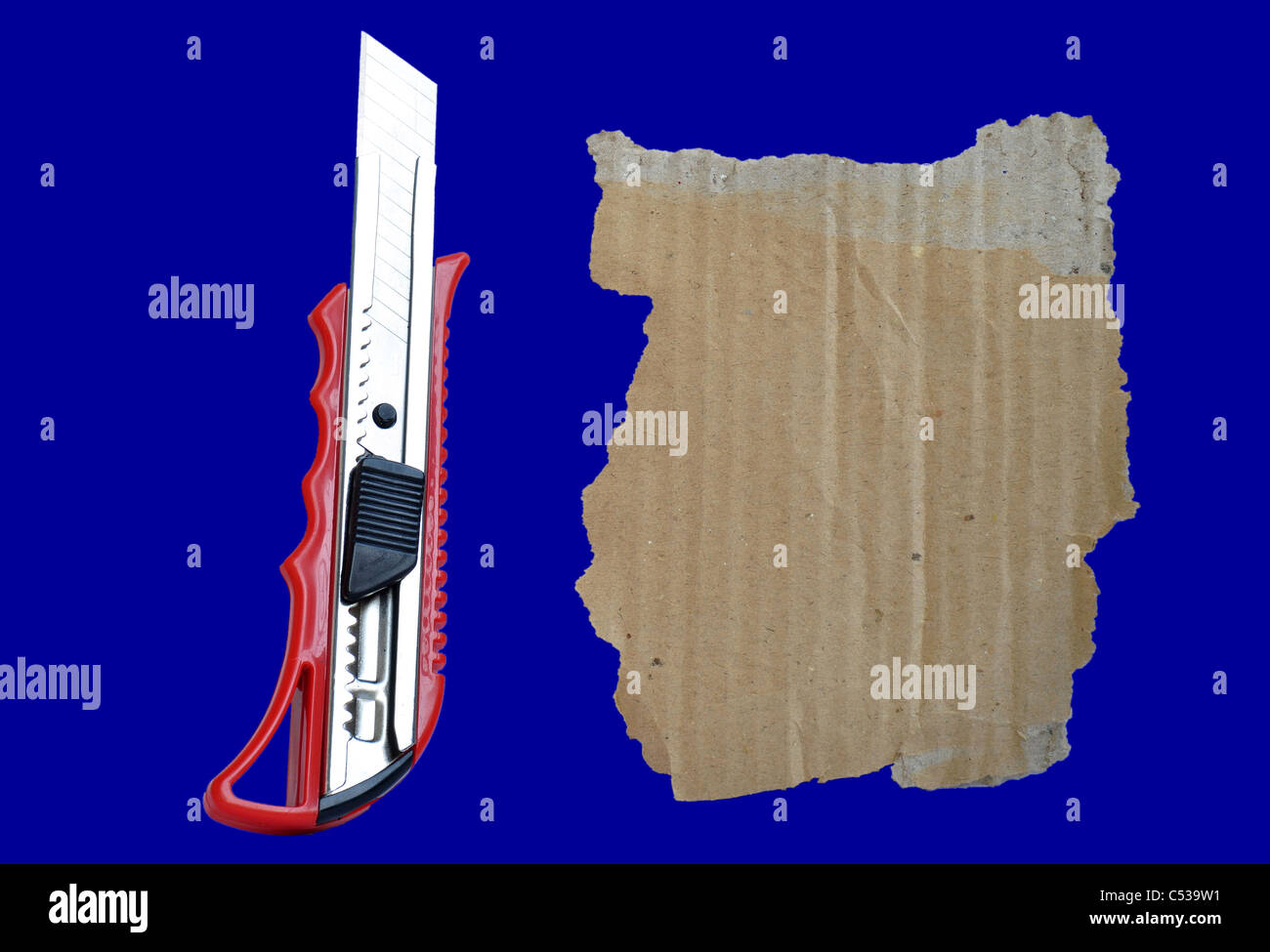 Paper knife and old cardboard isolated on a blue background Stock Photo ...
