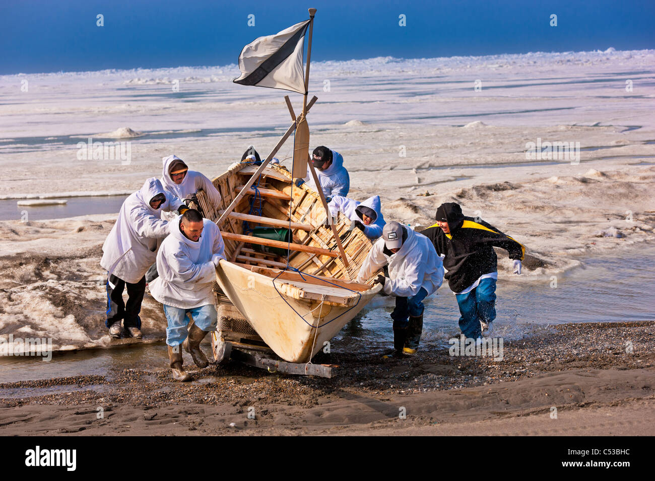 Whaling crew pushes their Umiaq off the Chuchki Sea ice at the end of ...
