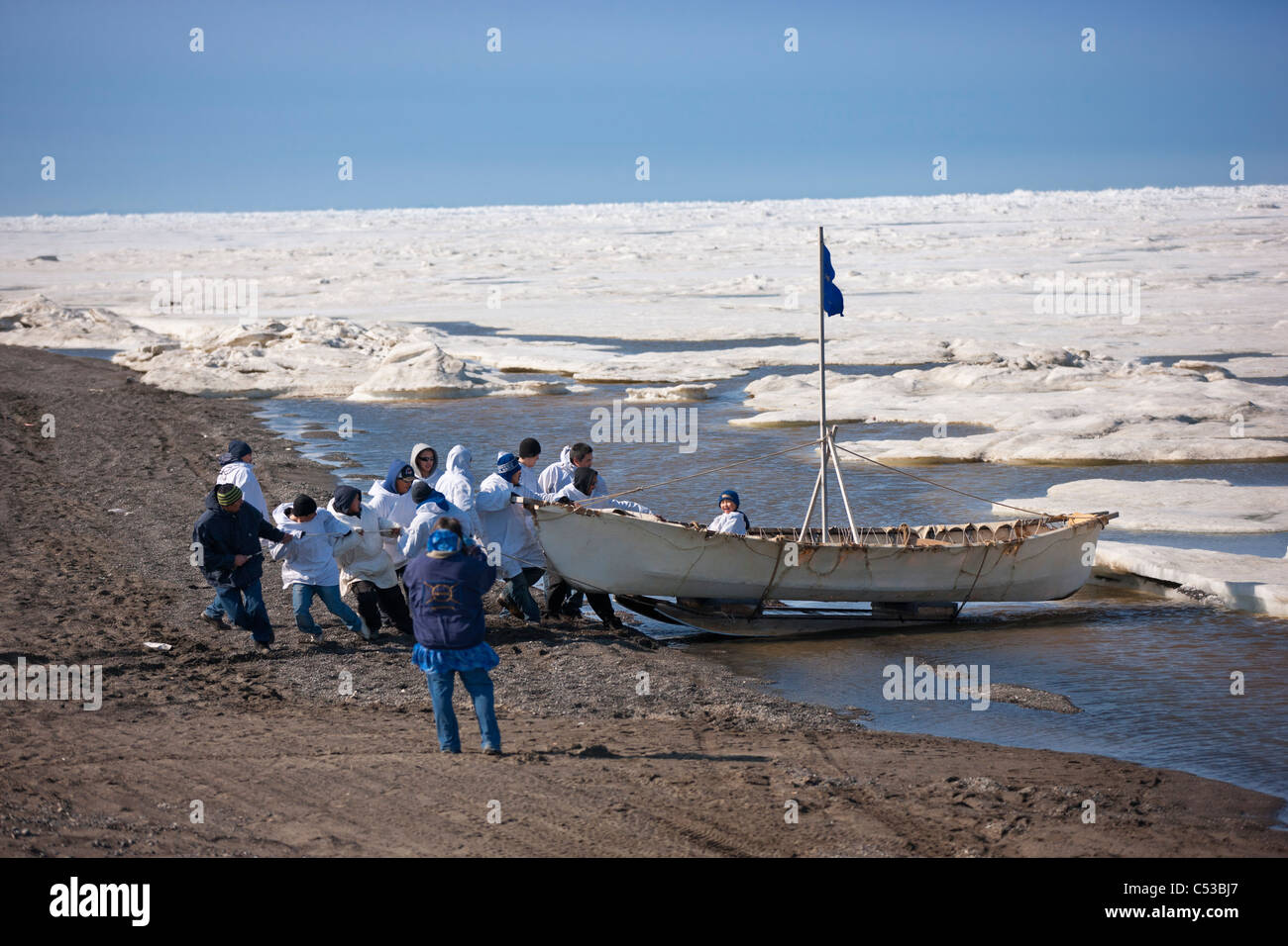 Whaling crew pushes their Umiaq off the Chuchki Sea ice at the end of ...