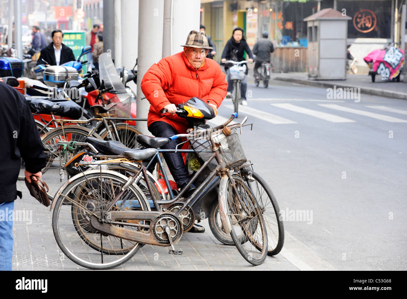 A Chinese man getting on his bike in Shanghai Stock Photo - Alamy