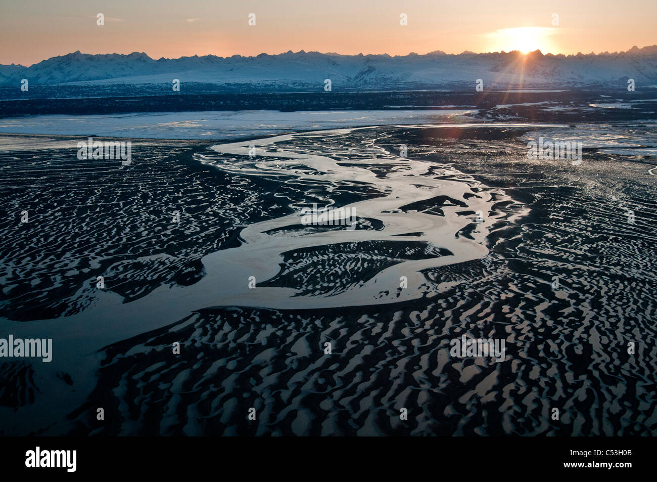Aerial evening view of the Chakachatna River and mudflats of Cook Inlet ...