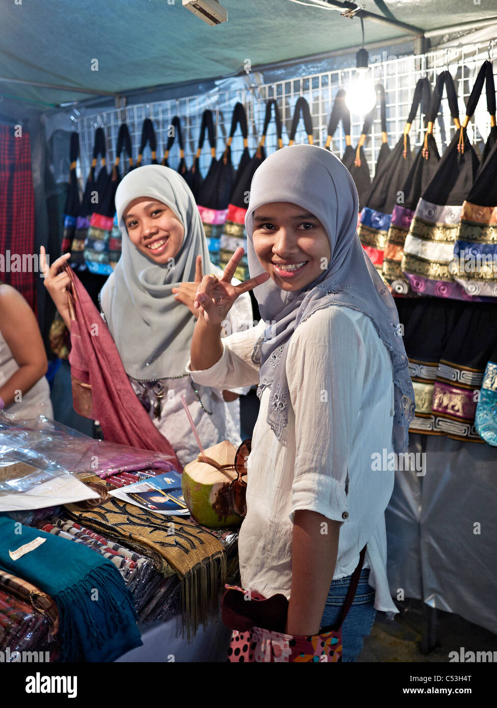 Muslim girls wearing traditional hijab pose for the camera whilst ...