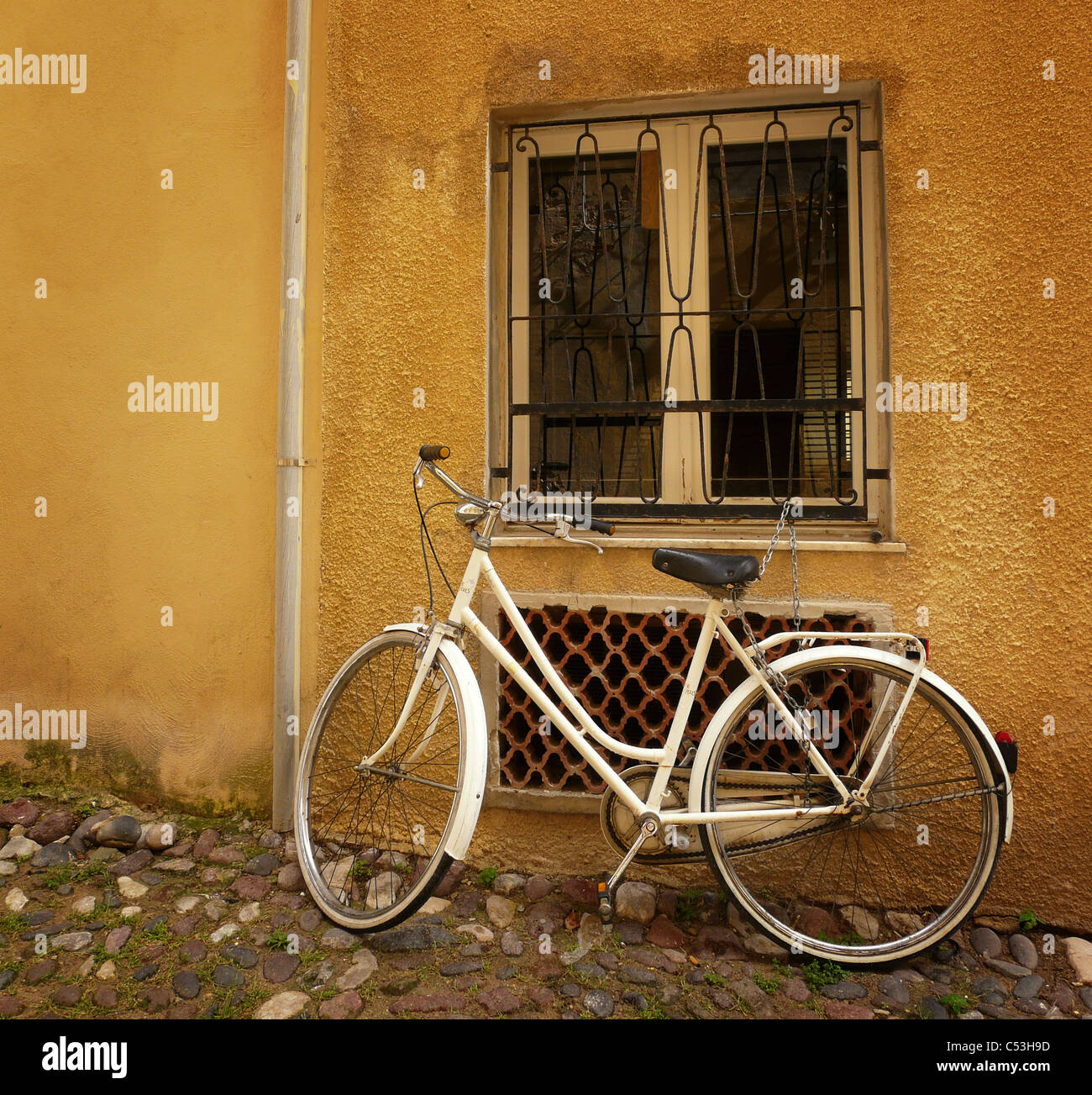 Old bicycle standing against a wall under a window Stock Photo - Alamy