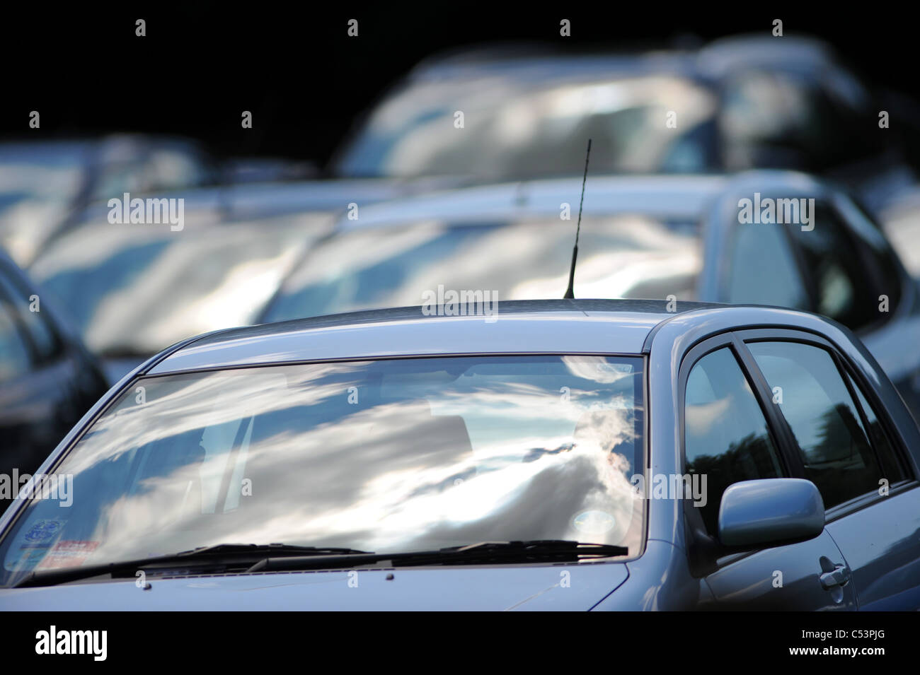 The sun glints and glares of car windscreens in a car park UK Stock ...